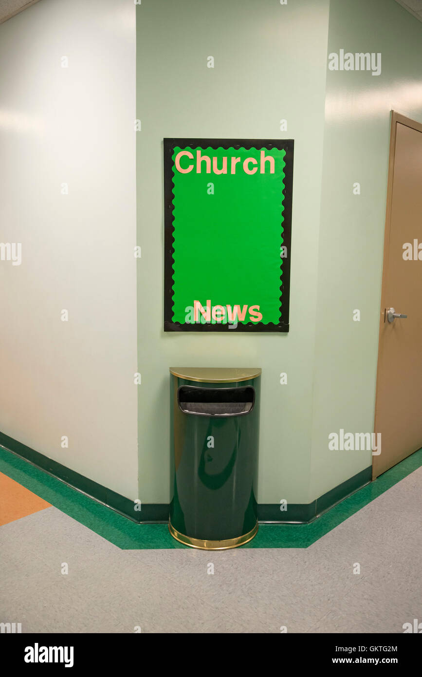 Church News bulletin board hangs above trash can in the hallway of a ...
