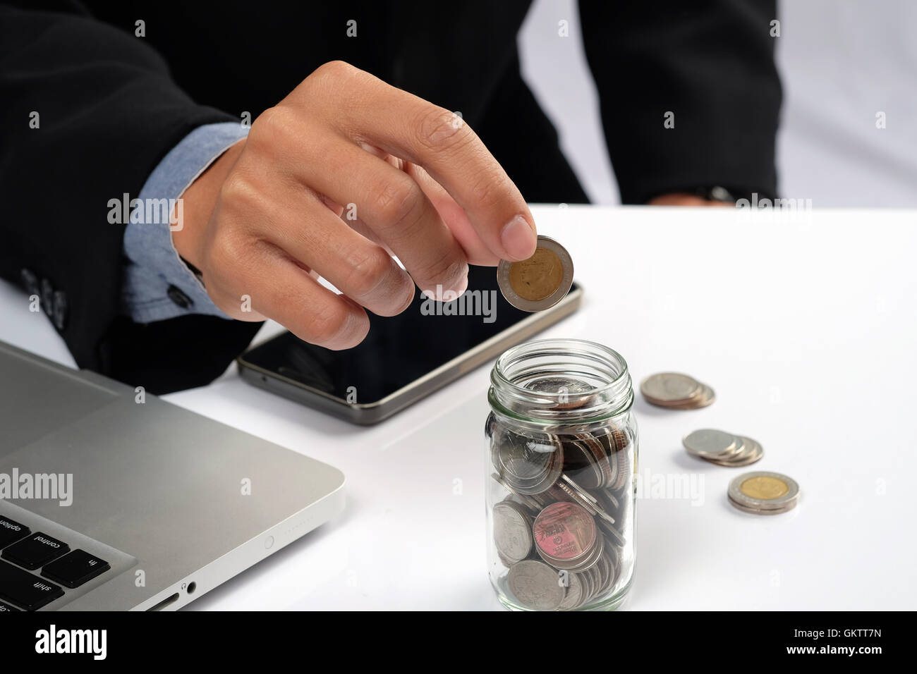 Businessman putting coins hi-res stock photography and images - Alamy