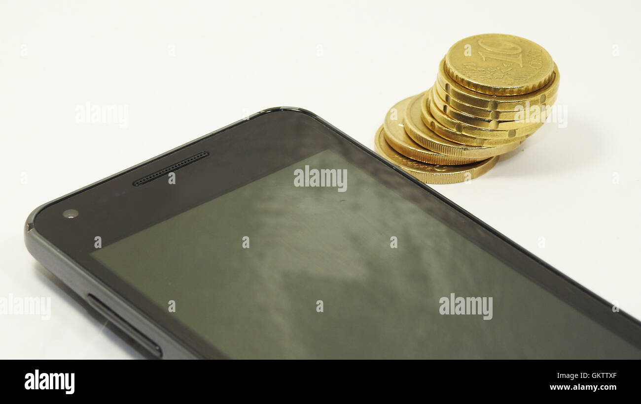 Mobile phone with coins Stock Photo - Alamy
