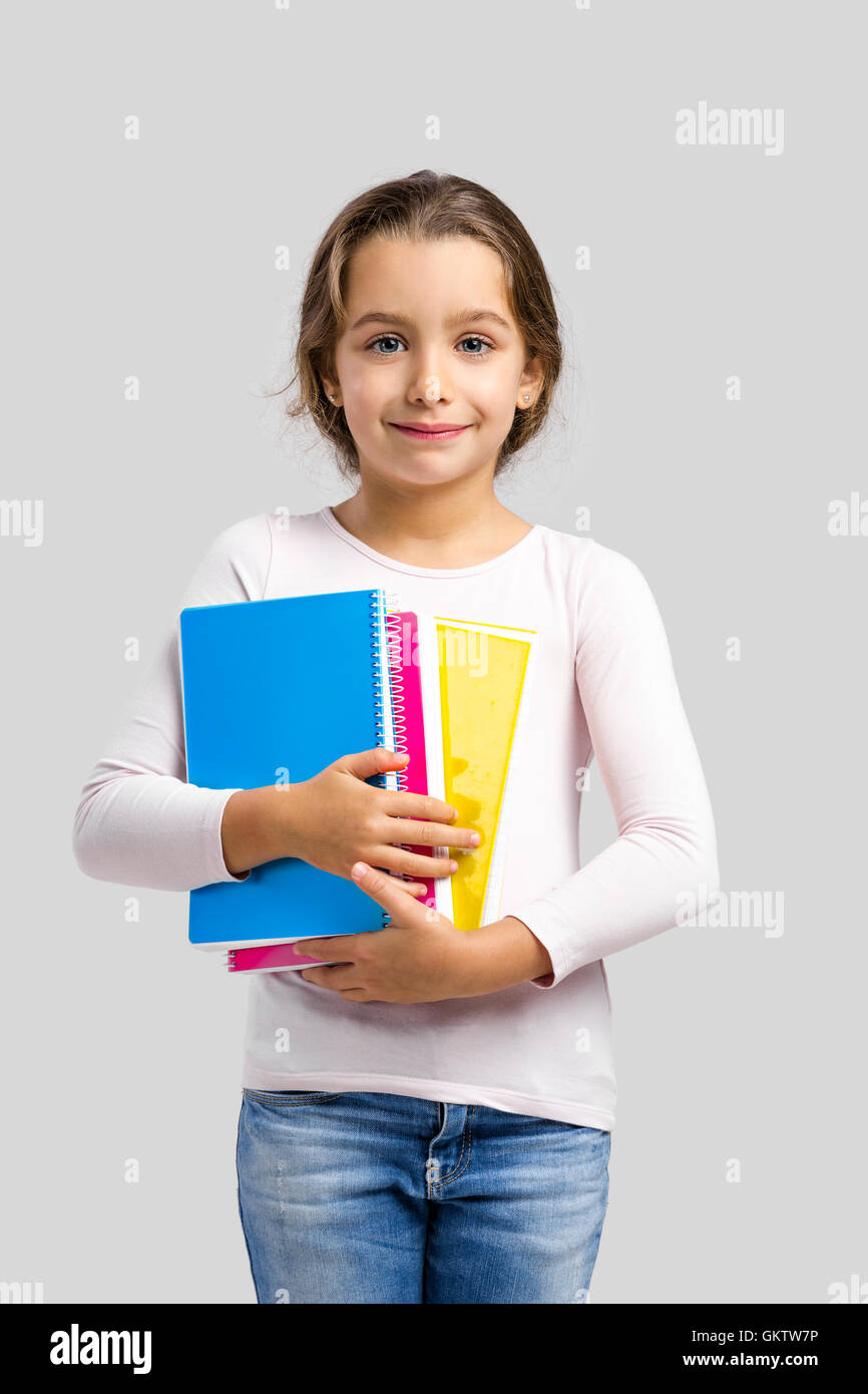 Smiling little student girl holding notebooks Stock Photo - Alamy
