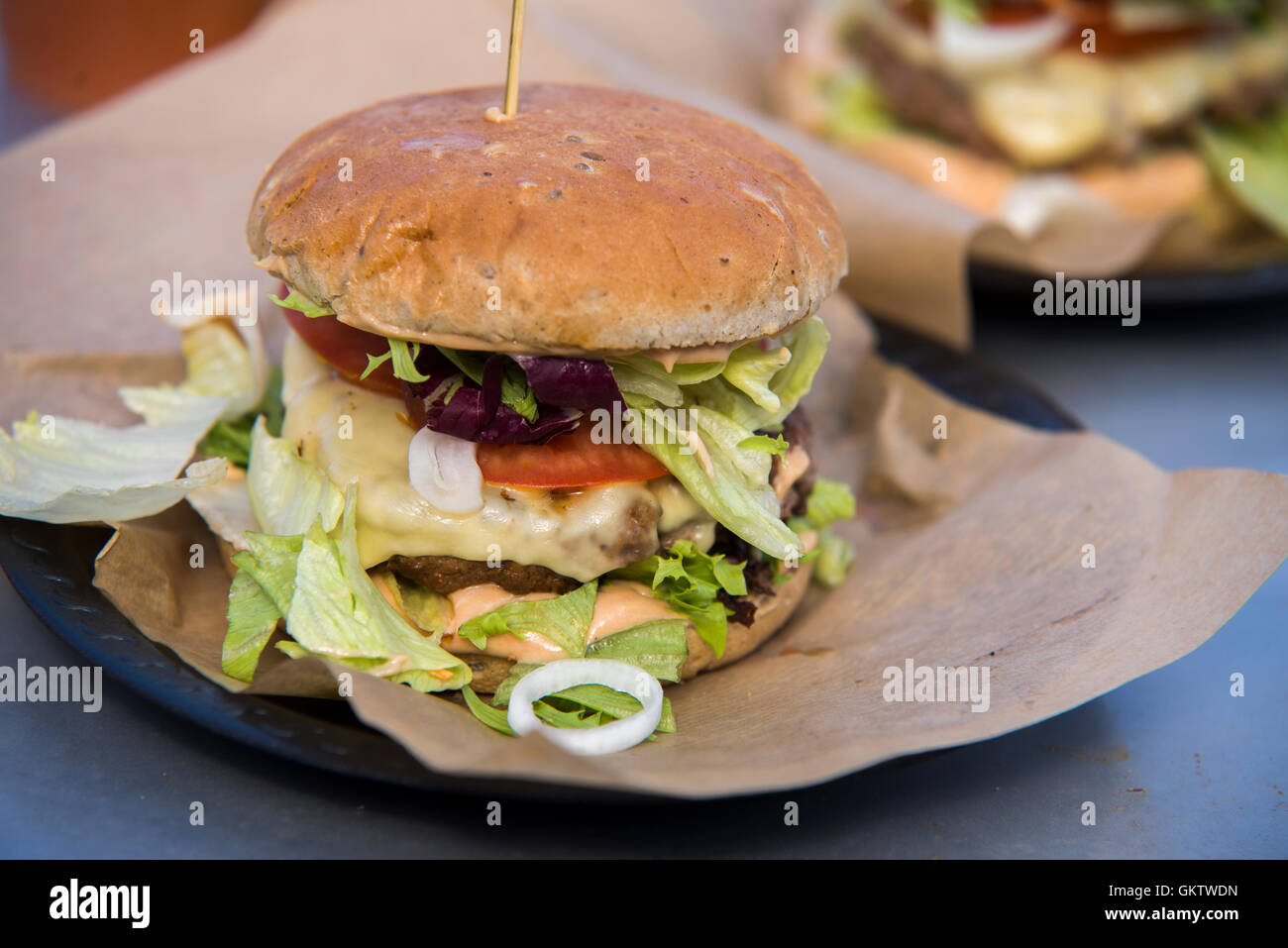 close on fast food unhealthy burger on paper Stock Photo - Alamy