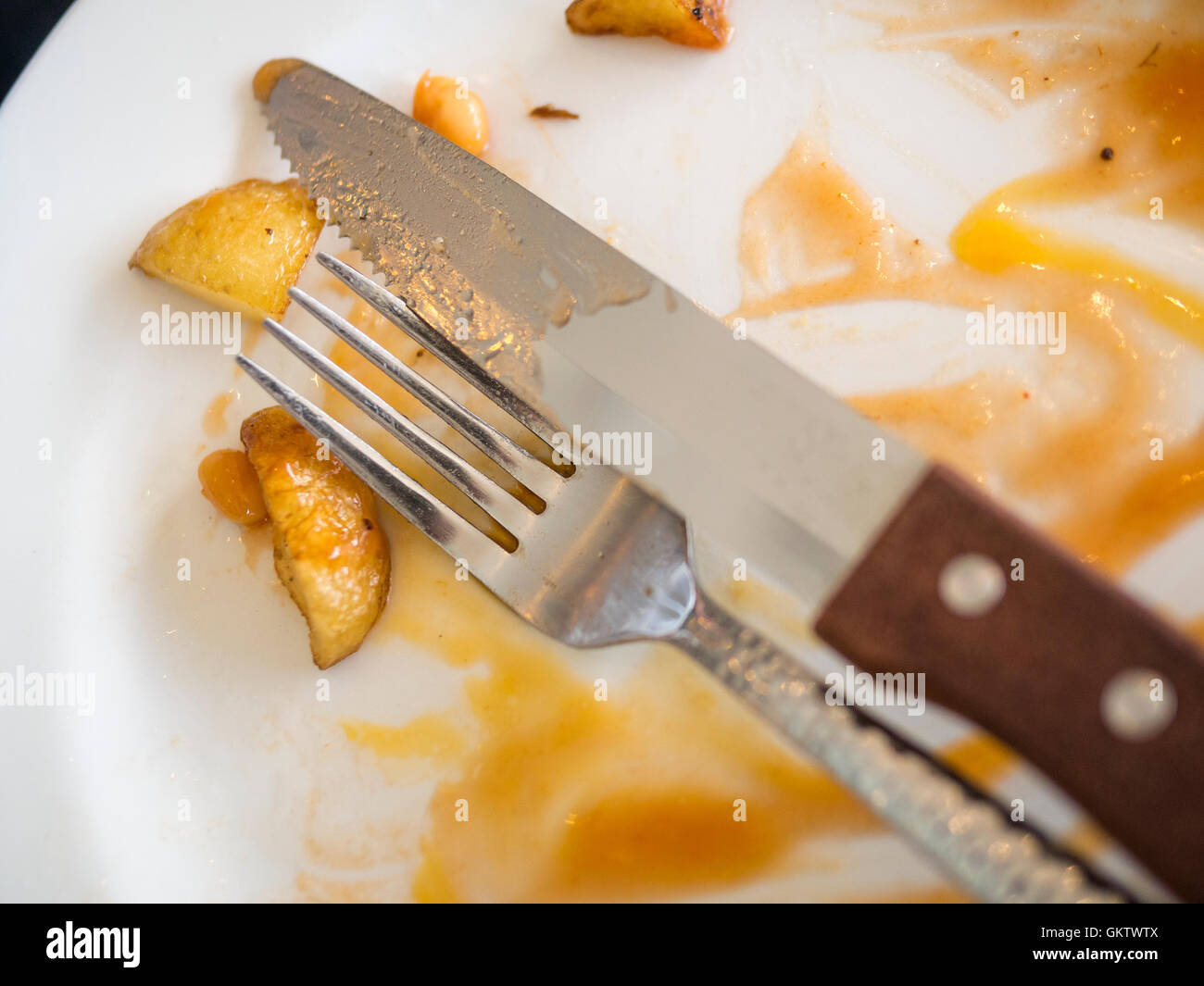 Knife and Fork on Plate with Leftover Food Stock Photo - Alamy