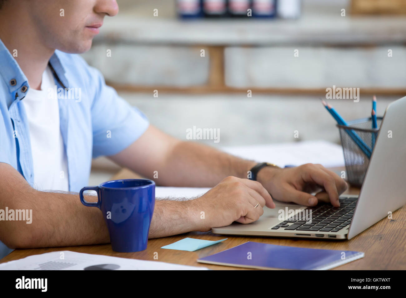 Young business man working on laptop in home office interior in loft ...