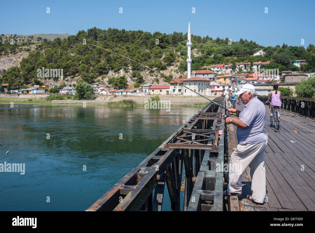 Fishing on the bridge across the Buna river which flows into Lake ...