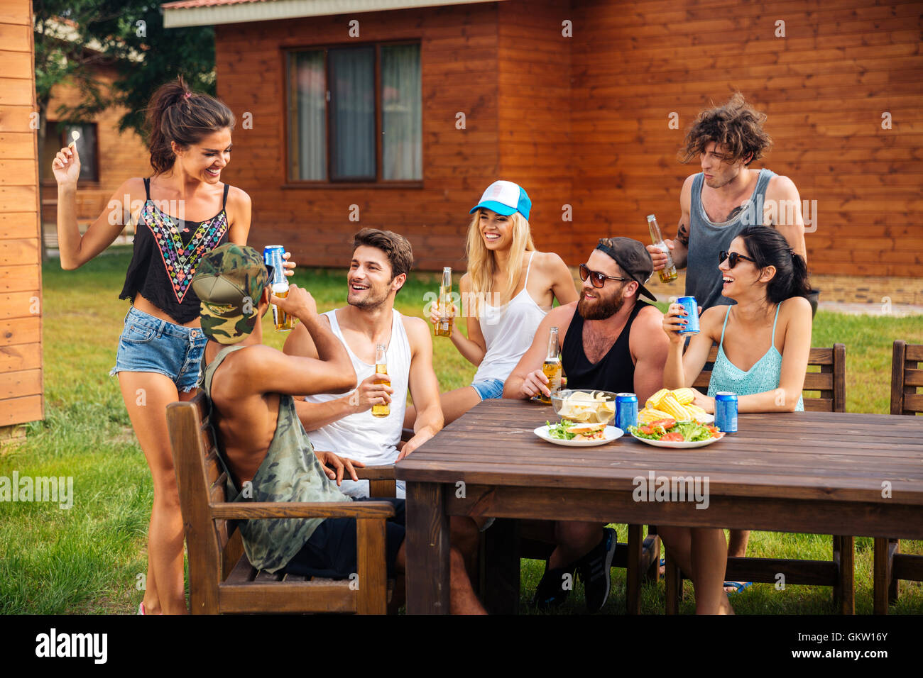 Group of happy young people celebrating and having party at the table ...