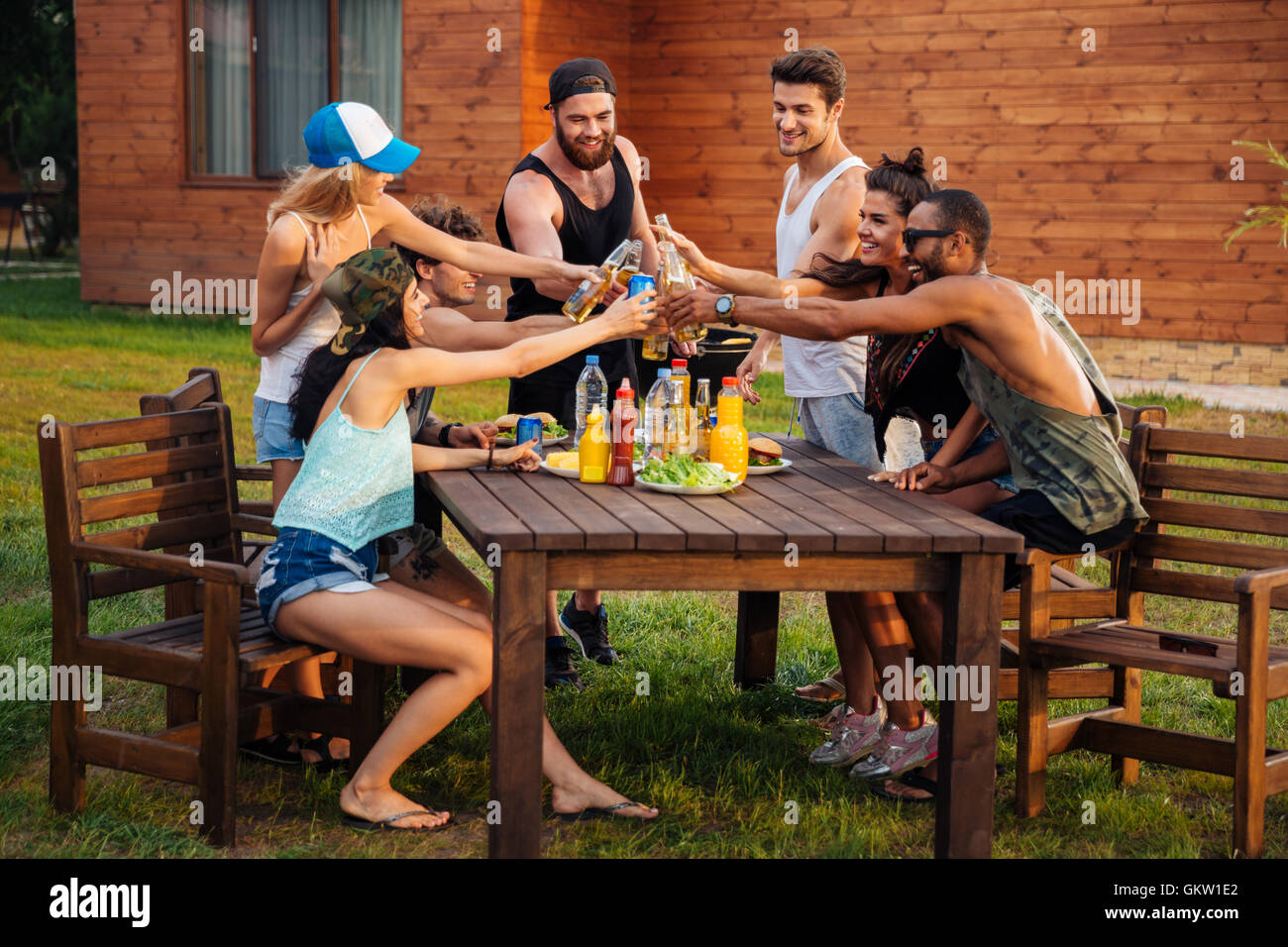 Group of happy young people celebrating and drinking beer and soda at ...