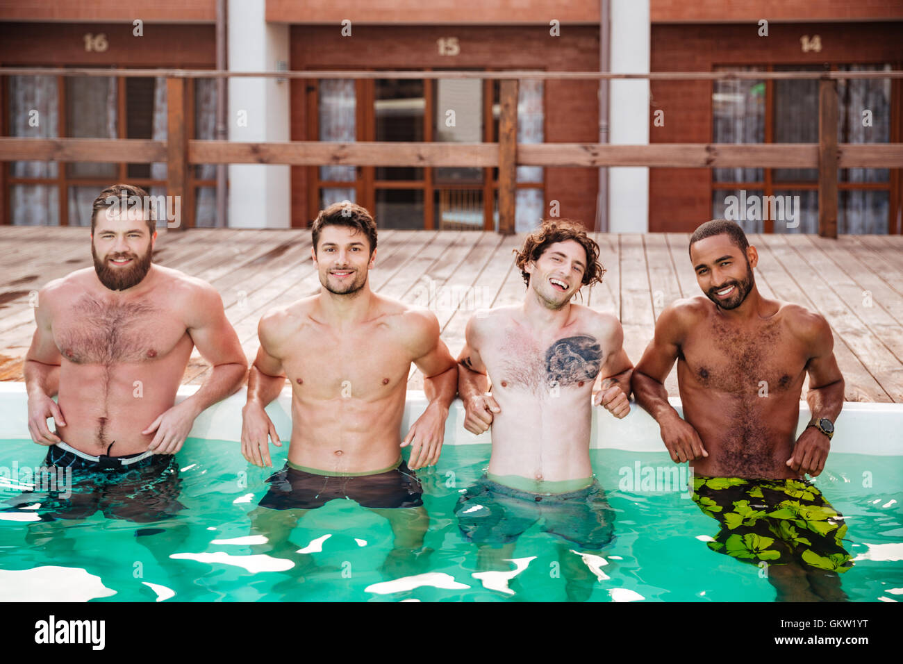 Group of happy confident young men standing in swimming pool Stock ...