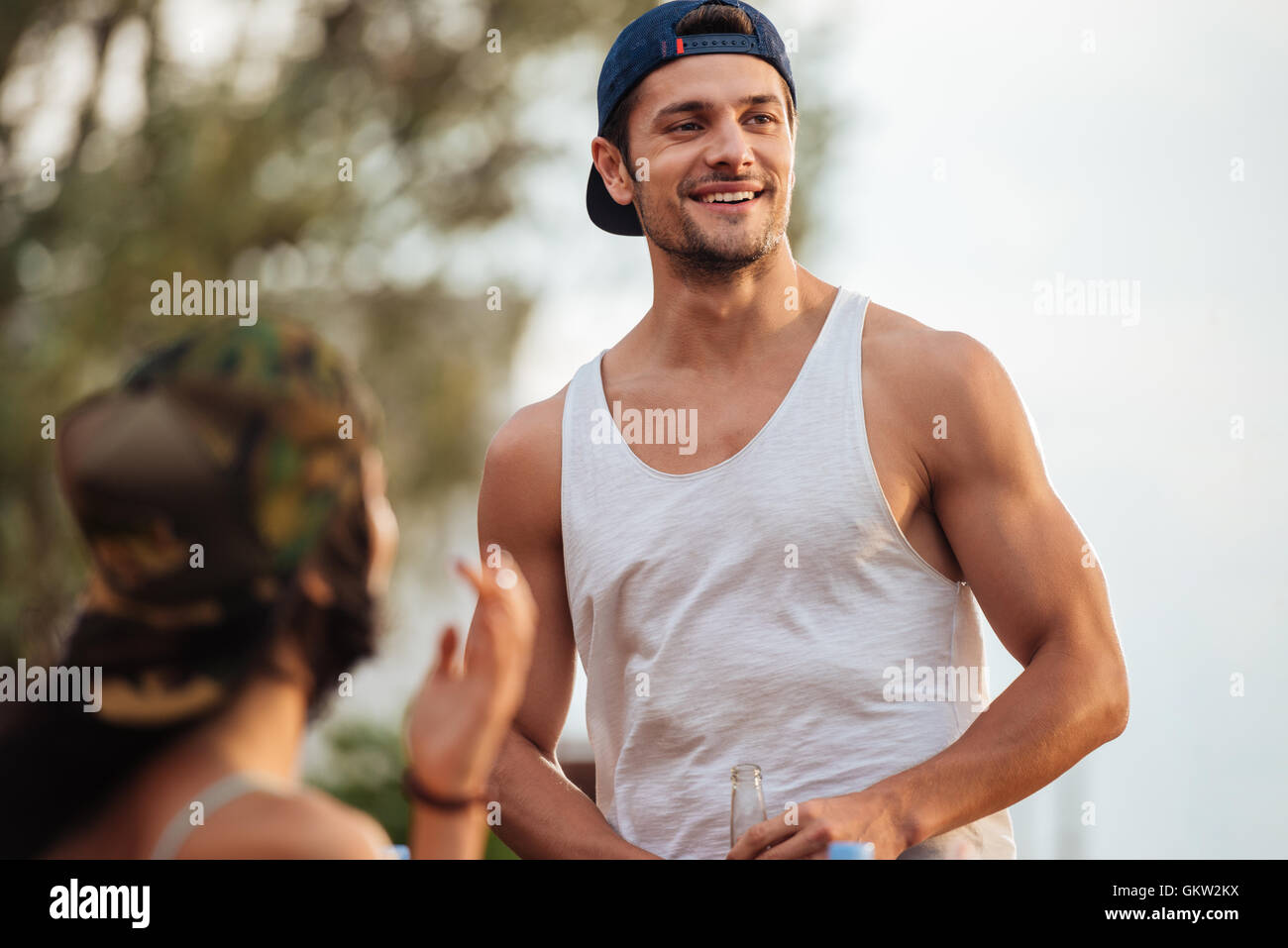 Potrait of smiling handsome young man in cap standing outdoors Stock ...