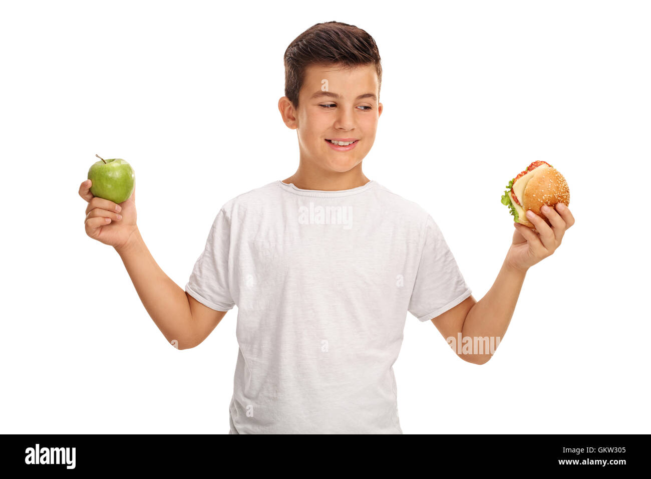 Indecisive kid holding an apple and a sandwich isolated on white ...