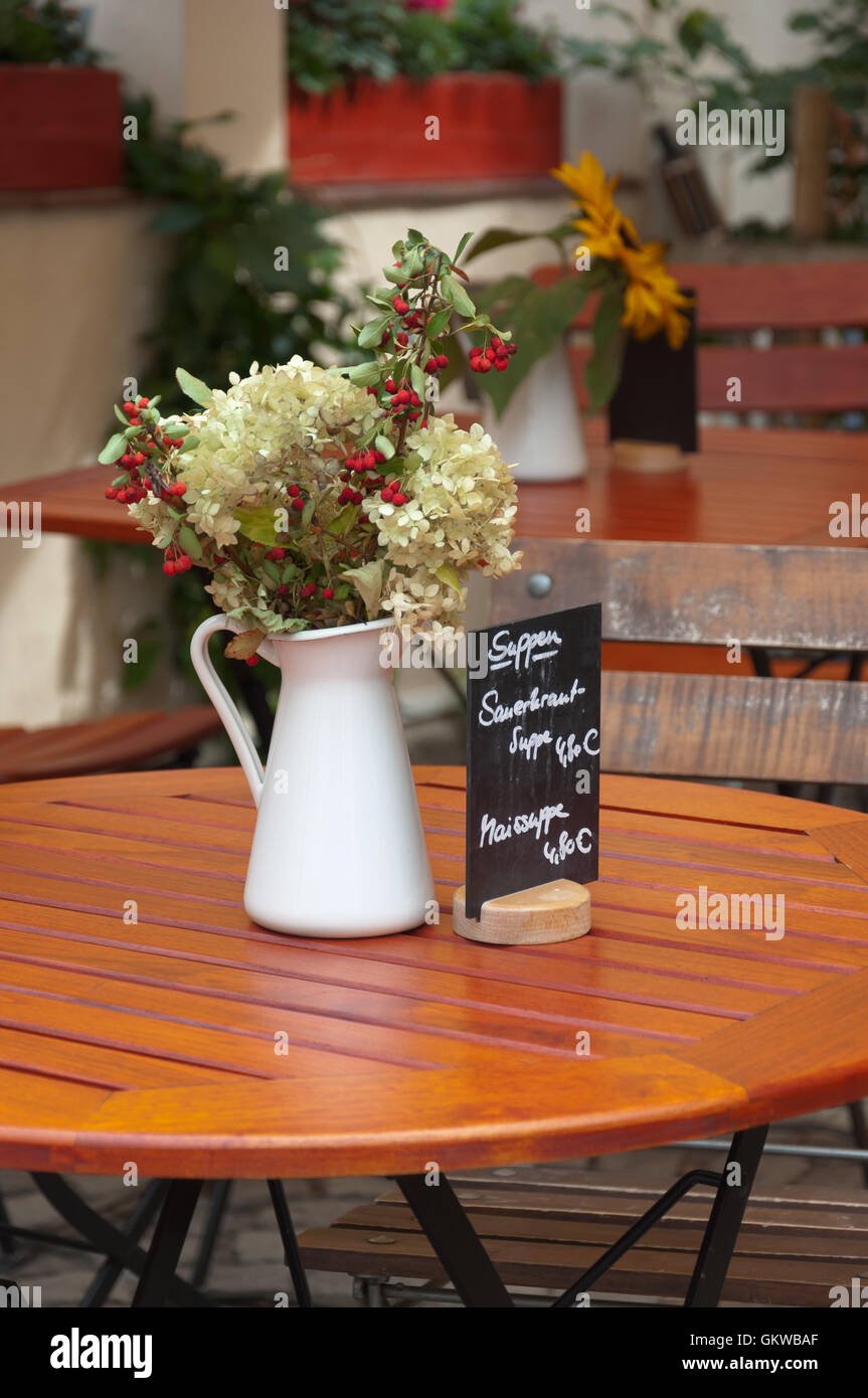 Flowers in pitcher on table Stock Photo - Alamy