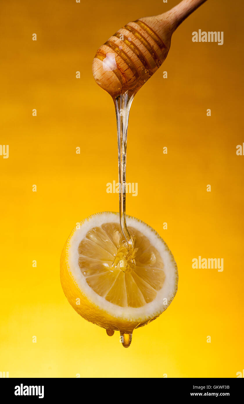 Honey flowing on lemon Stock Photo - Alamy