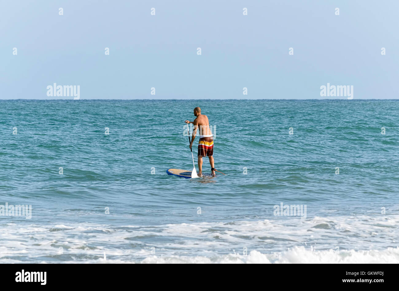 Stand up paddle surfing. Surfer over his surfboard, in the beach of ...