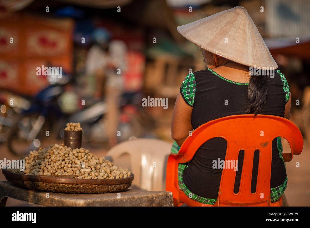 Woman selling peanuts in street market Stock Photo - Alamy