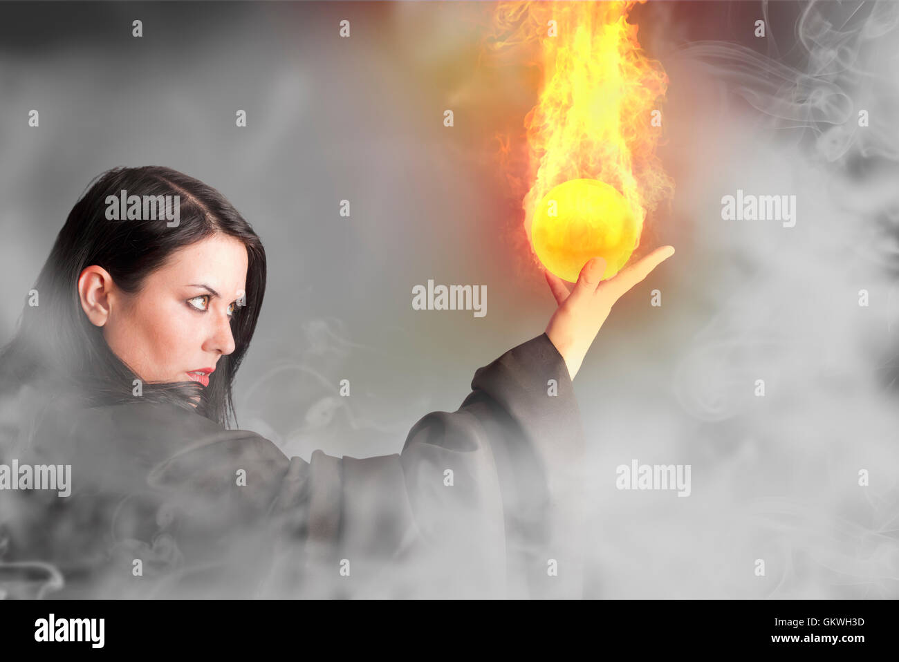 Magician woman with a fire ball in her hands Stock Photo - Alamy