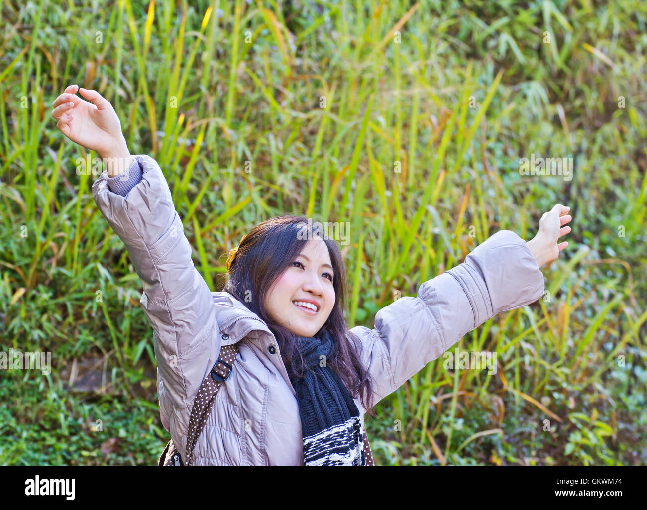 Happy young woman with hands up Stock Photo - Alamy