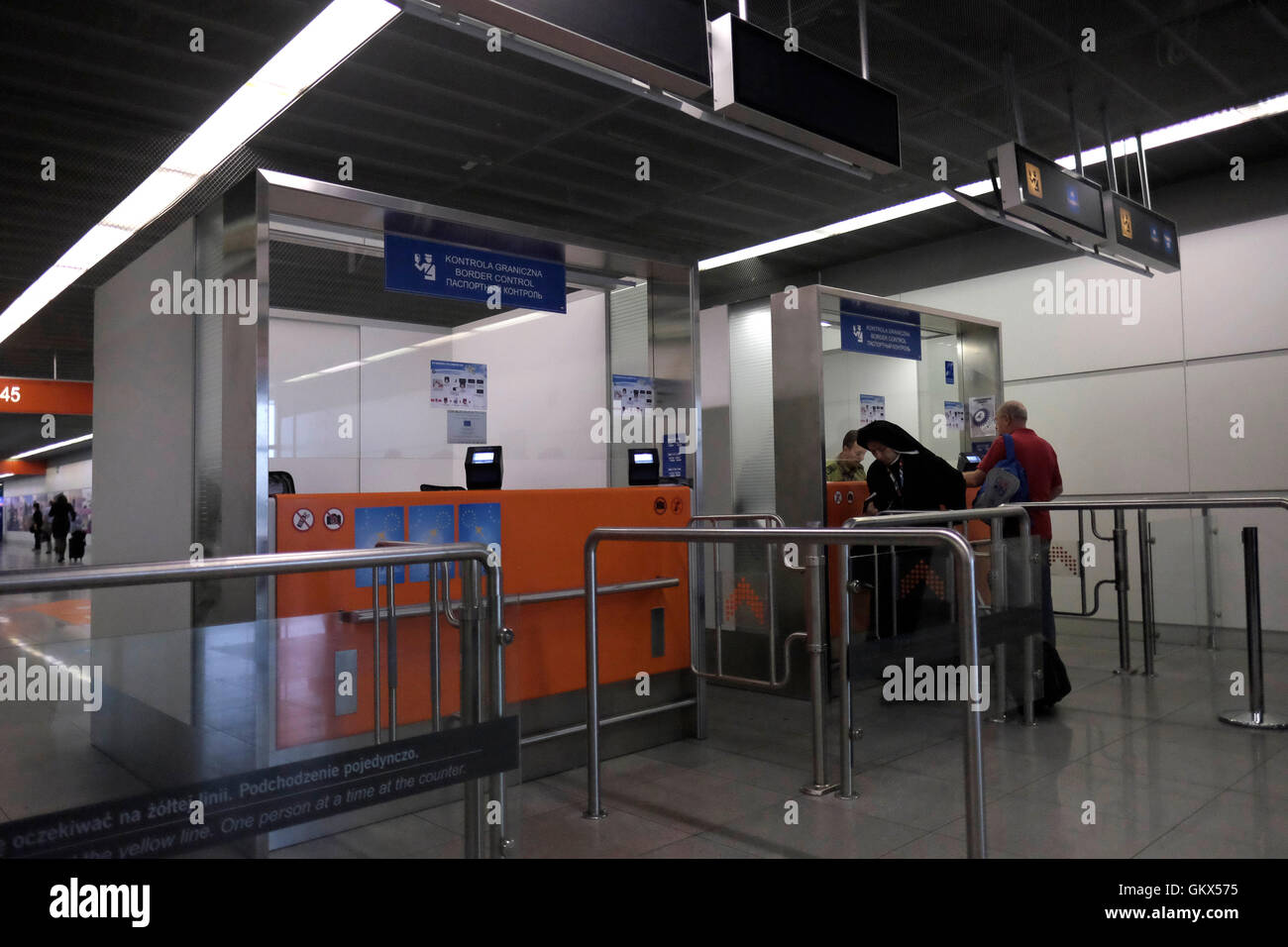 Passengers go through passport control booth at Chopin airport in ...
