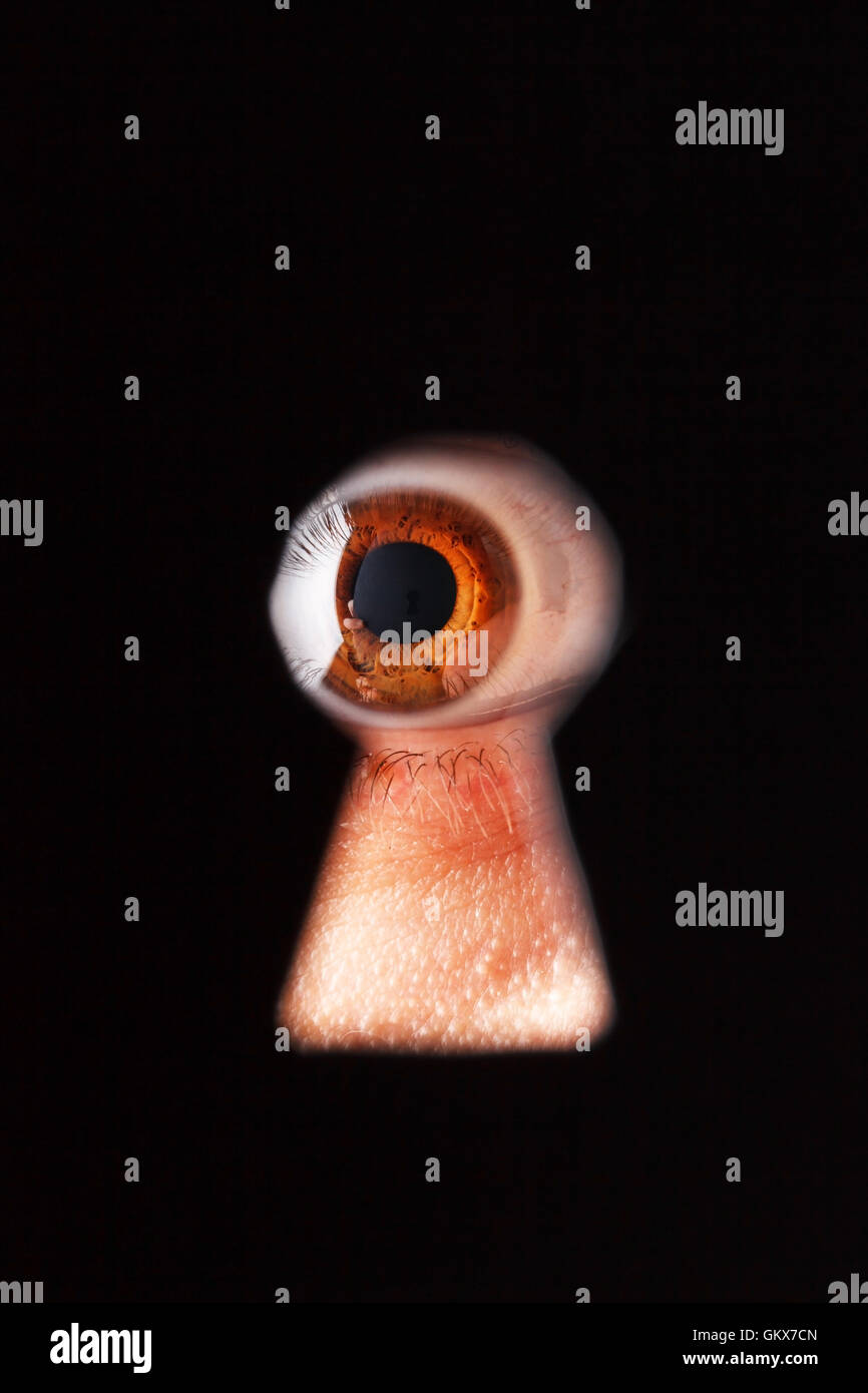 Eye looking through a keyhole Stock Photo - Alamy