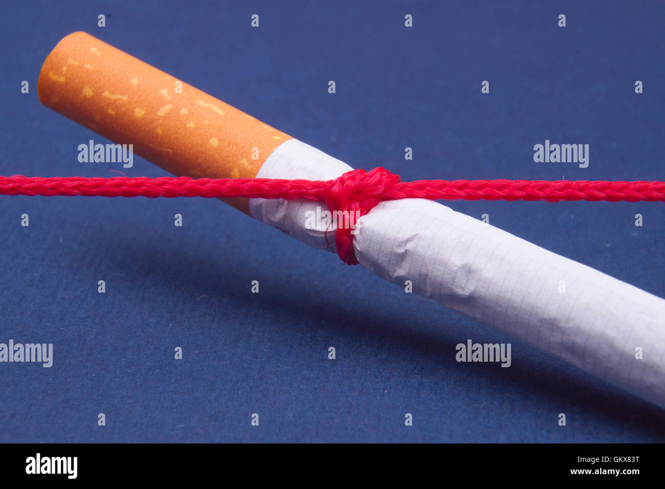 Cigarette tied up with red rope Stock Photo - Alamy