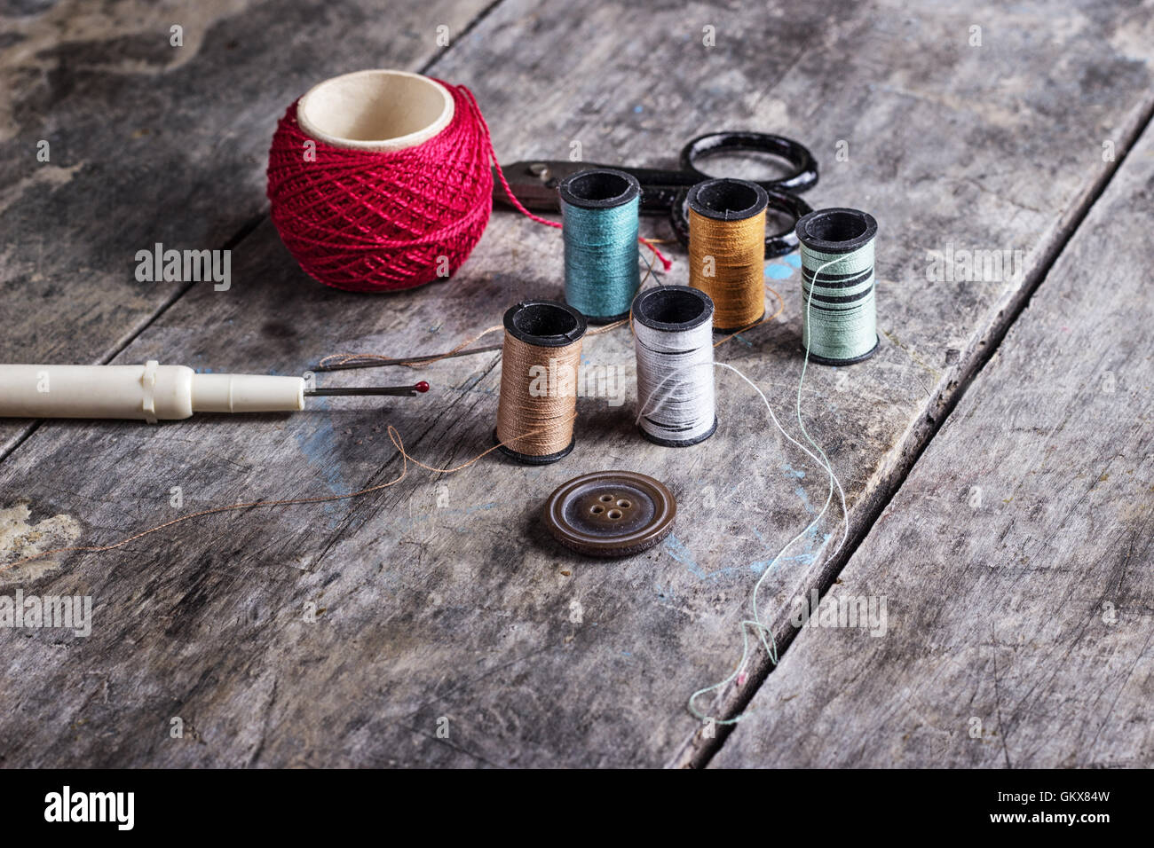 Many bobbin of thread with needle and button Stock Photo - Alamy