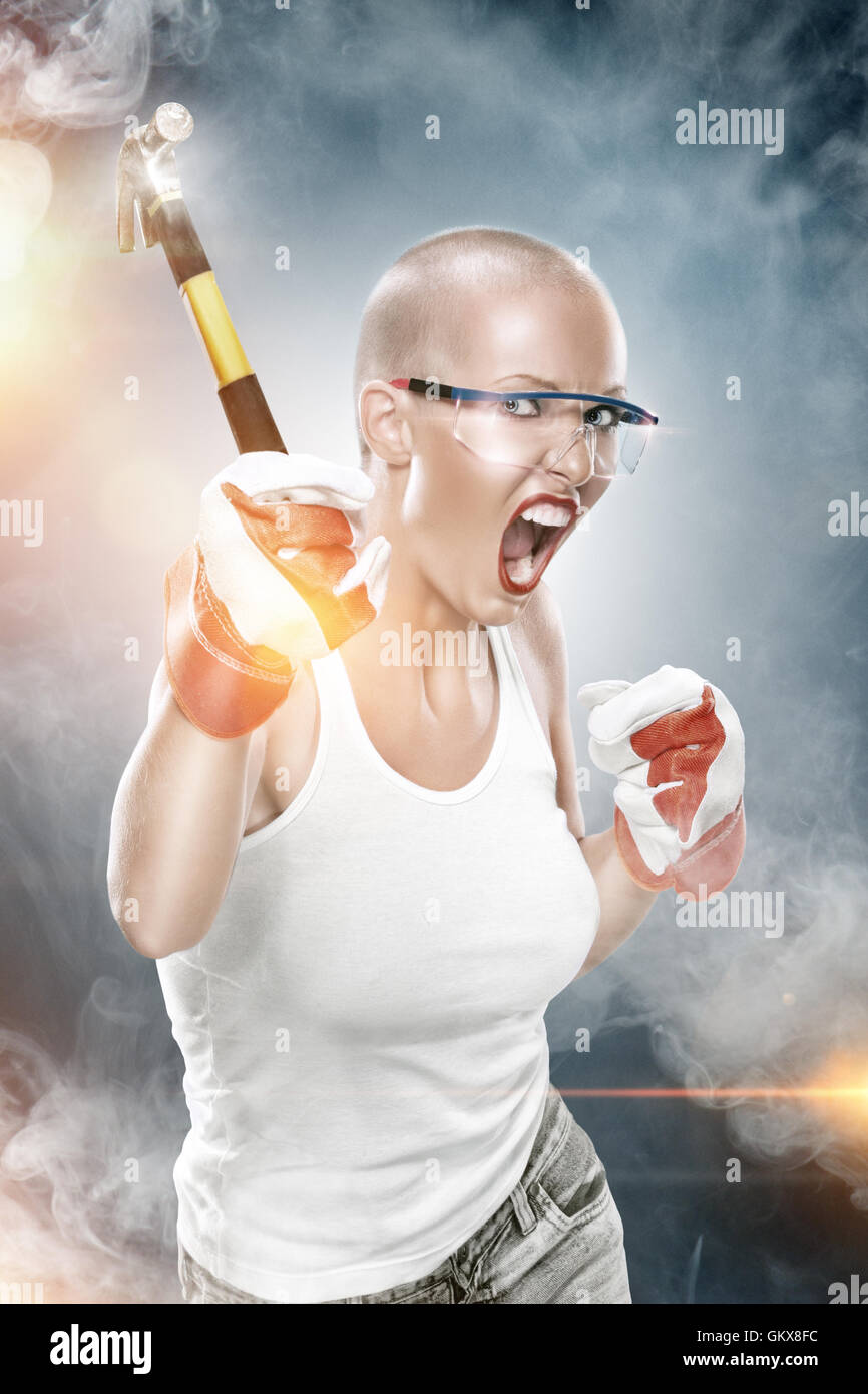 portrait of young beautiful woman with hammer on blue back Stock Photo ...
