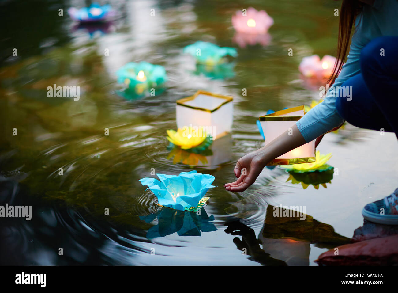 Traditional festive paper lilies with burning candles floating upon ...