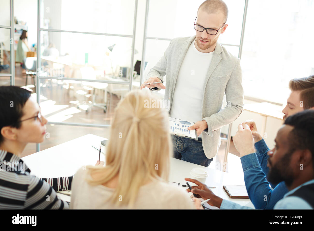 Serious employee explaining to his colleagues results of financial ...
