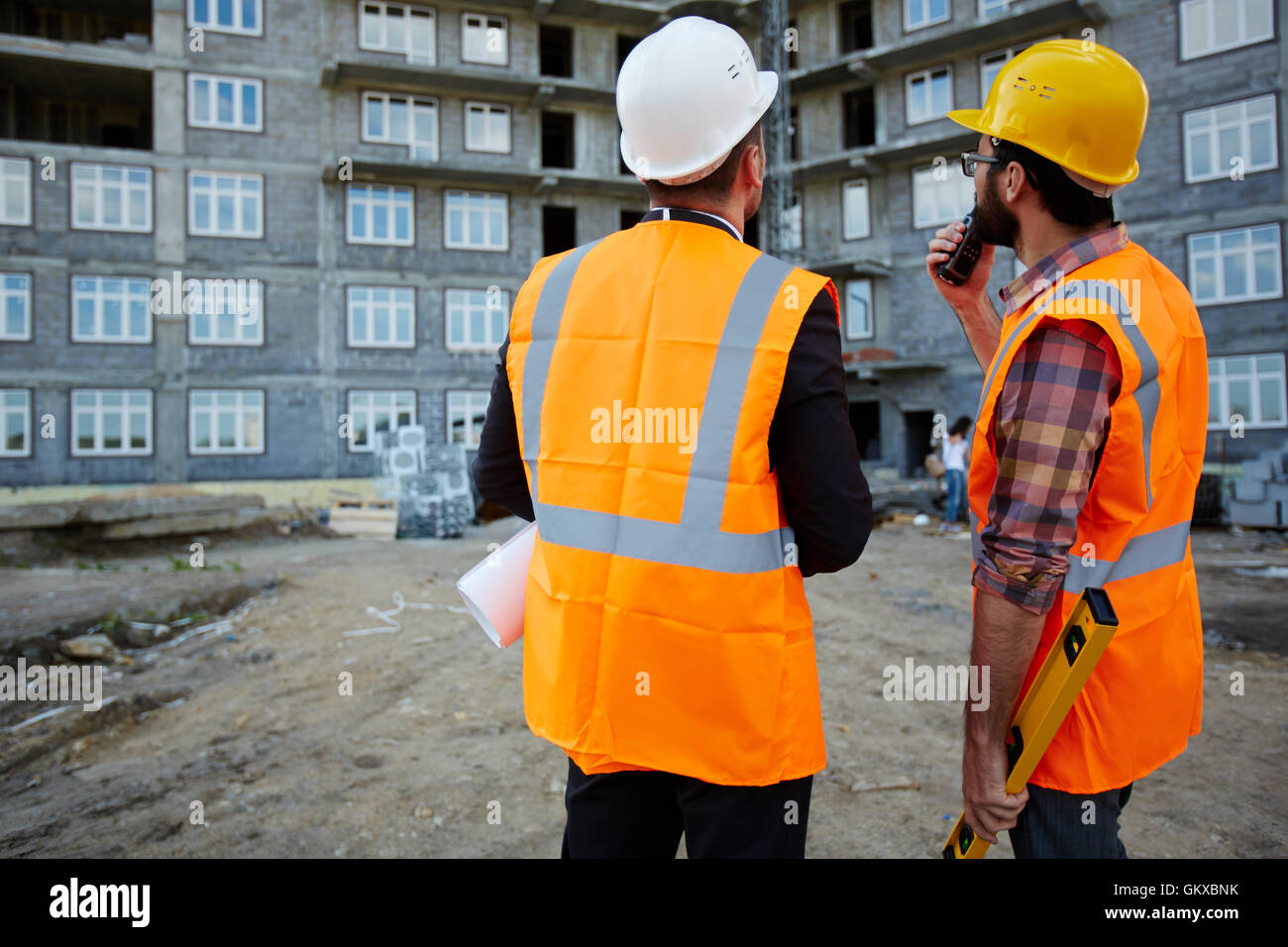 Two inspectors looking at new building while discussing it Stock Photo ...