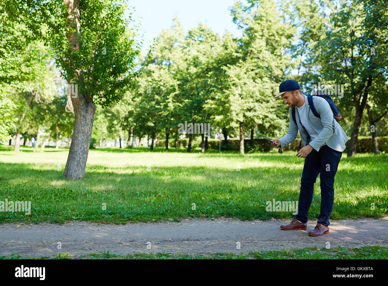 Active young man playing mobile game outdoors Stock Photo - Alamy