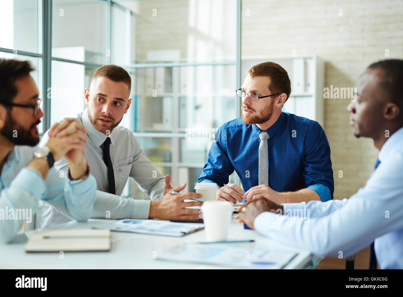 Male employees listening to colleague at briefing Stock Photo - Alamy