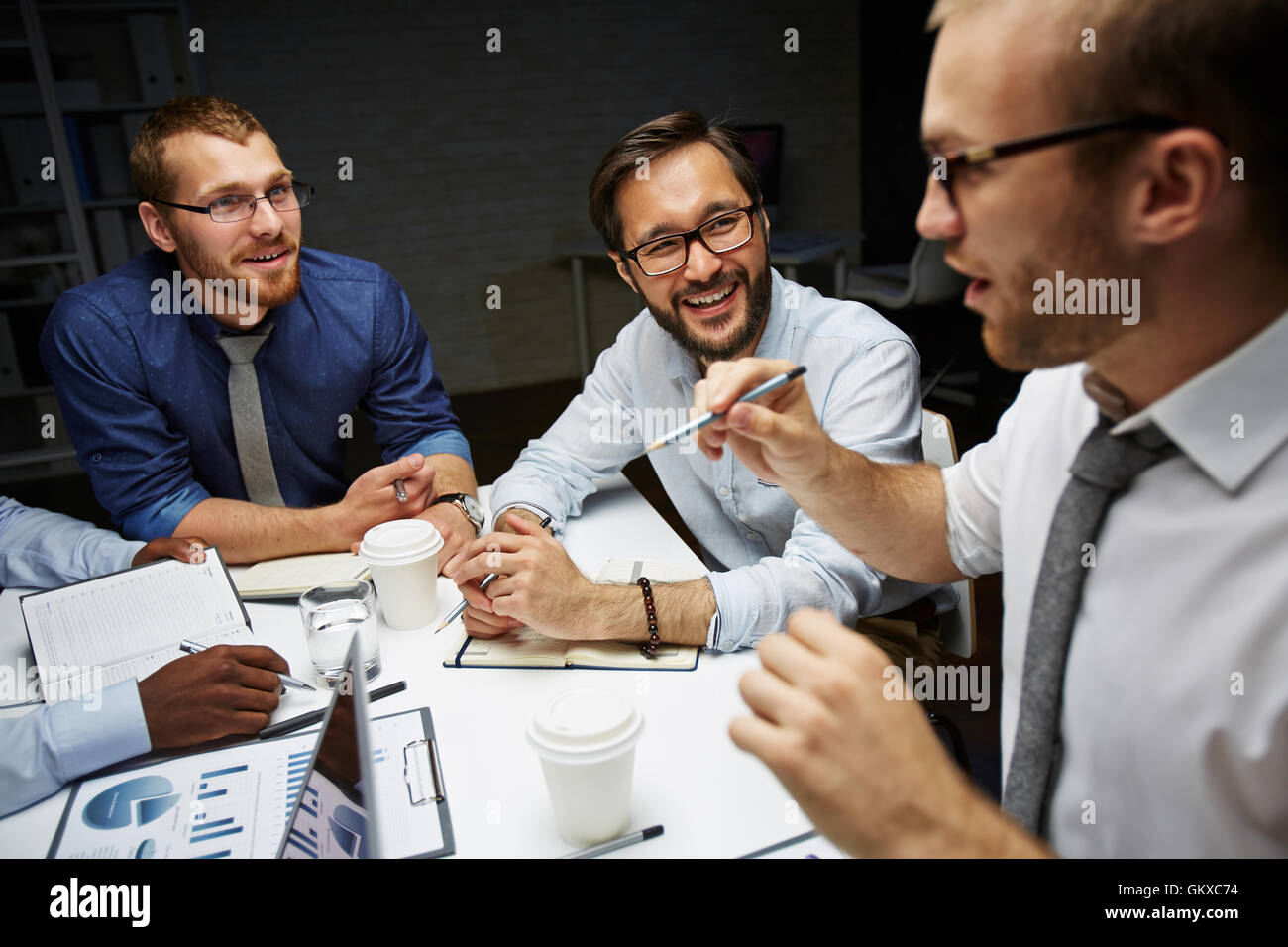 Businessmen communicating in office till late evening Stock Photo - Alamy