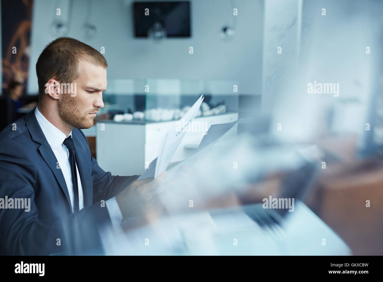 Serious manager looking through papers at work Stock Photo - Alamy