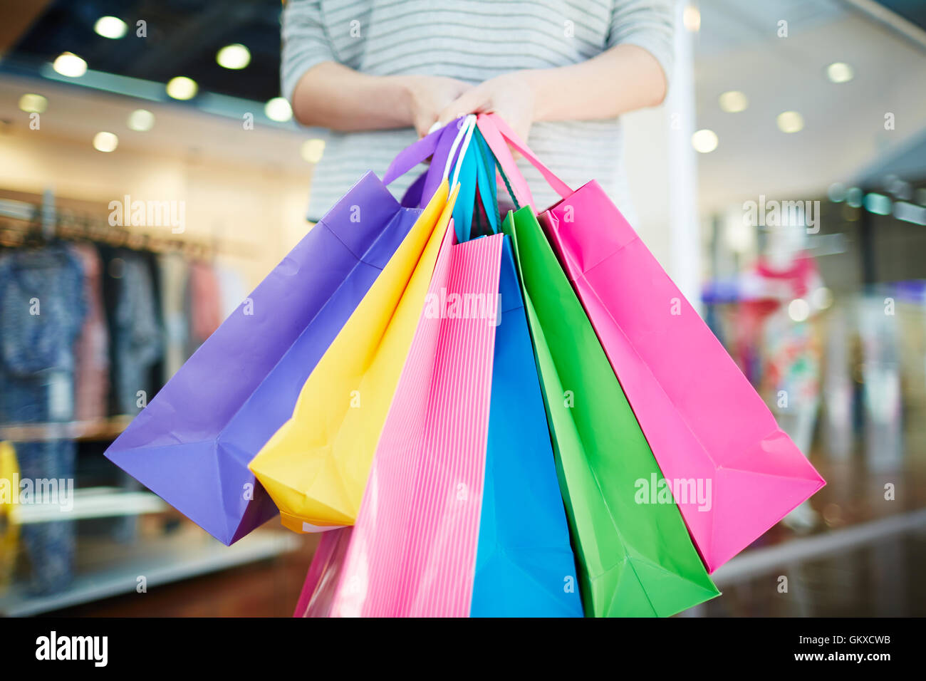 Multi-color paperbags held by young modern shopper Stock Photo - Alamy