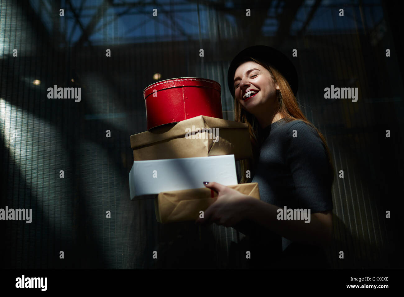 Laughing shopper carrying stack of boxes Stock Photo - Alamy