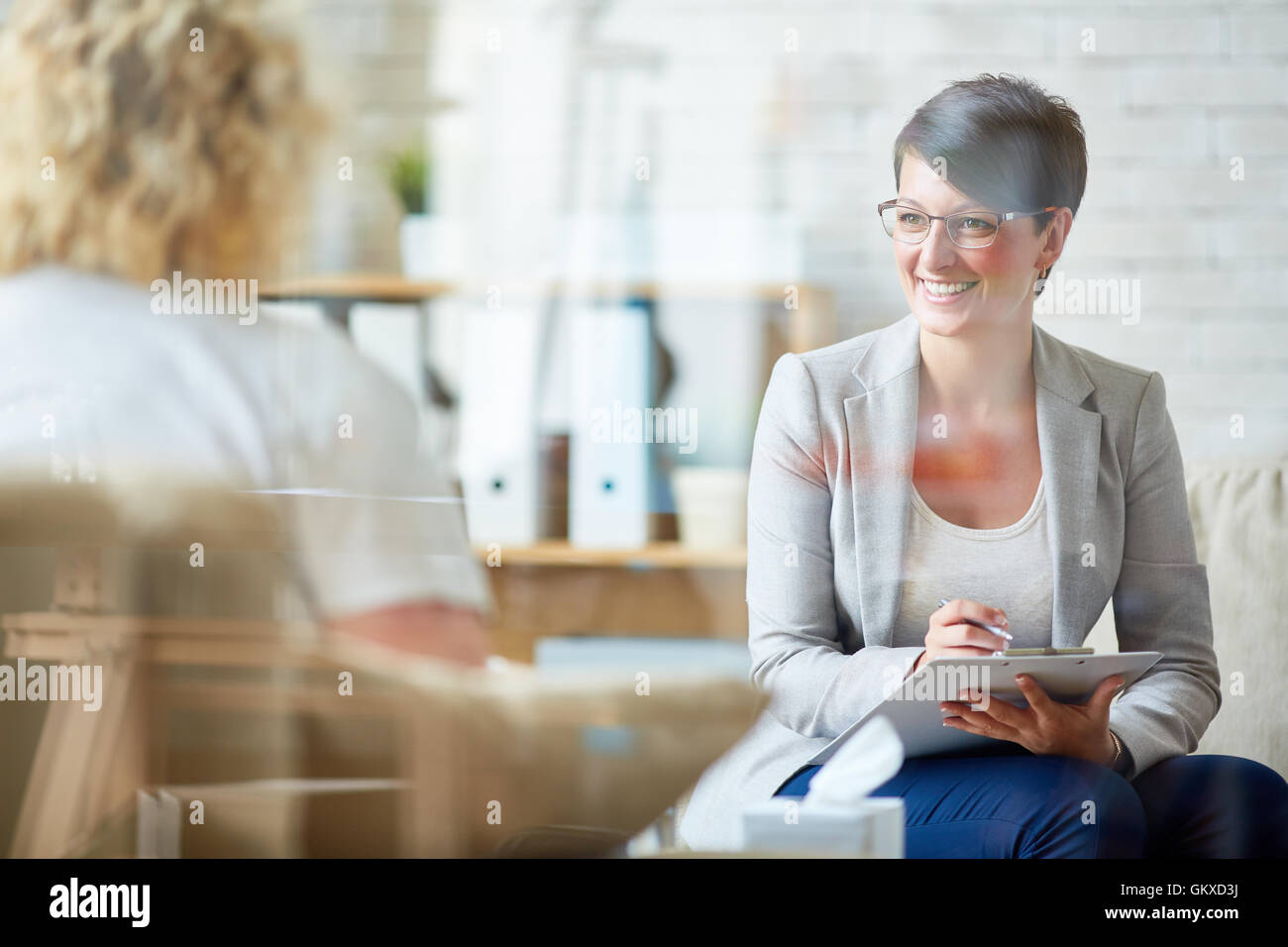 Happy psychologist listening to her patient problem Stock Photo - Alamy