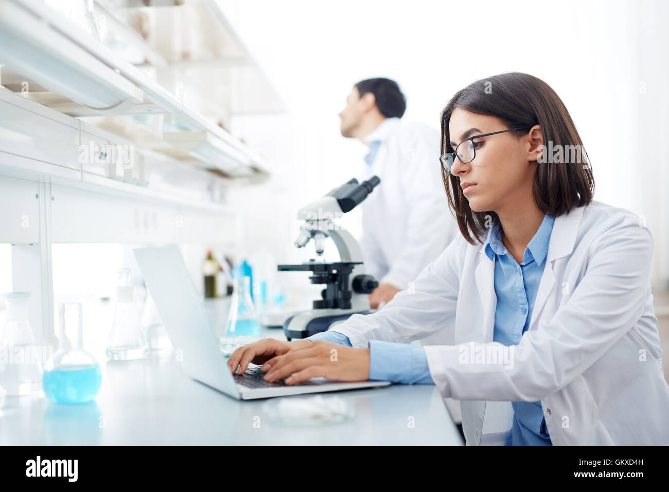 Female scientist typing in lab in working environment Stock Photo - Alamy