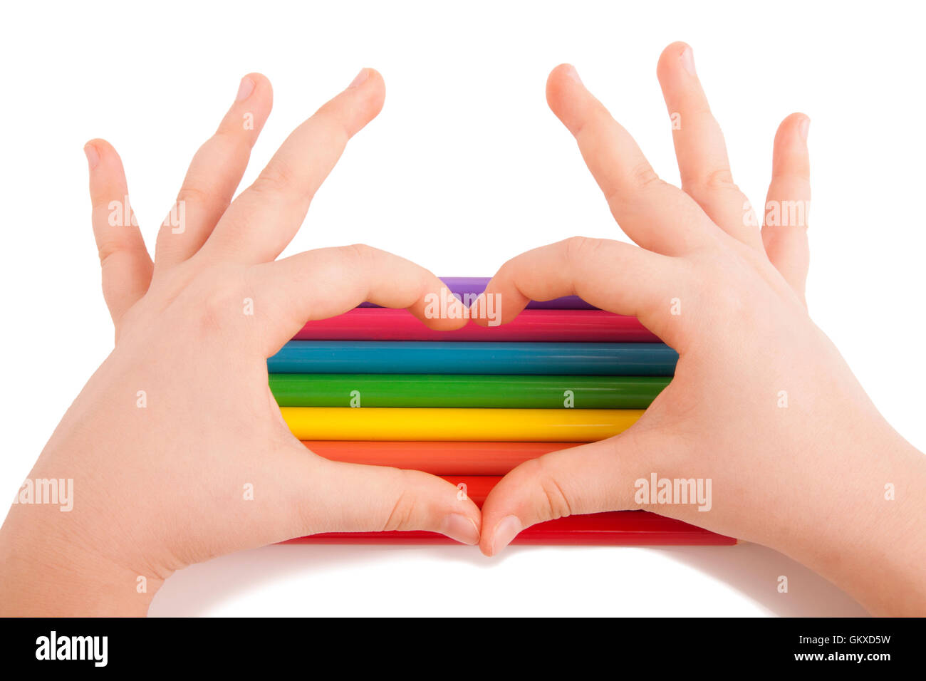 Child hands form a heart shape above color pencils Stock Photo - Alamy