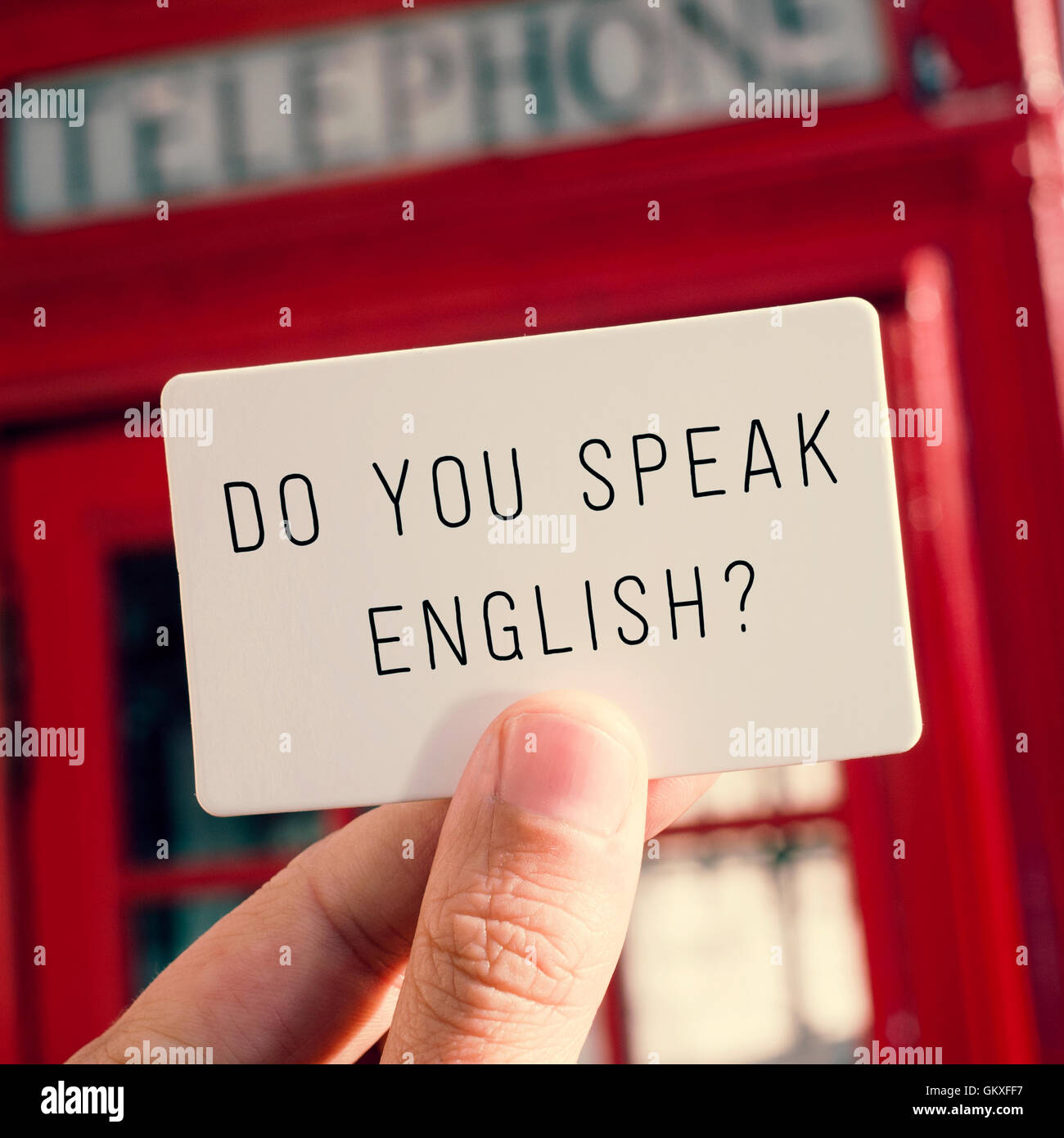 a man holding a signboard with the text do you speak english? with a ...