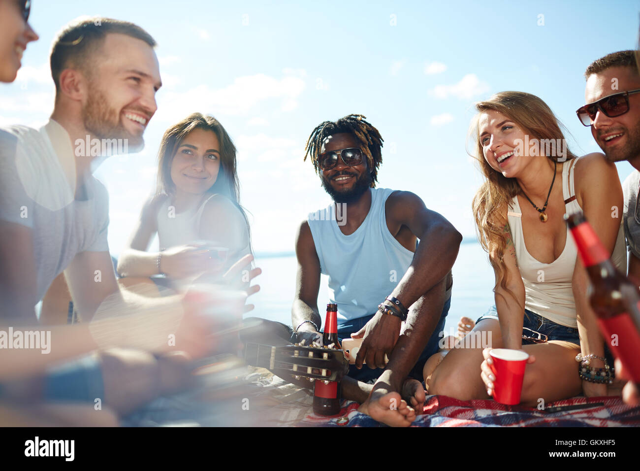 Group of joyful friends having nice time on the beach Stock Photo - Alamy