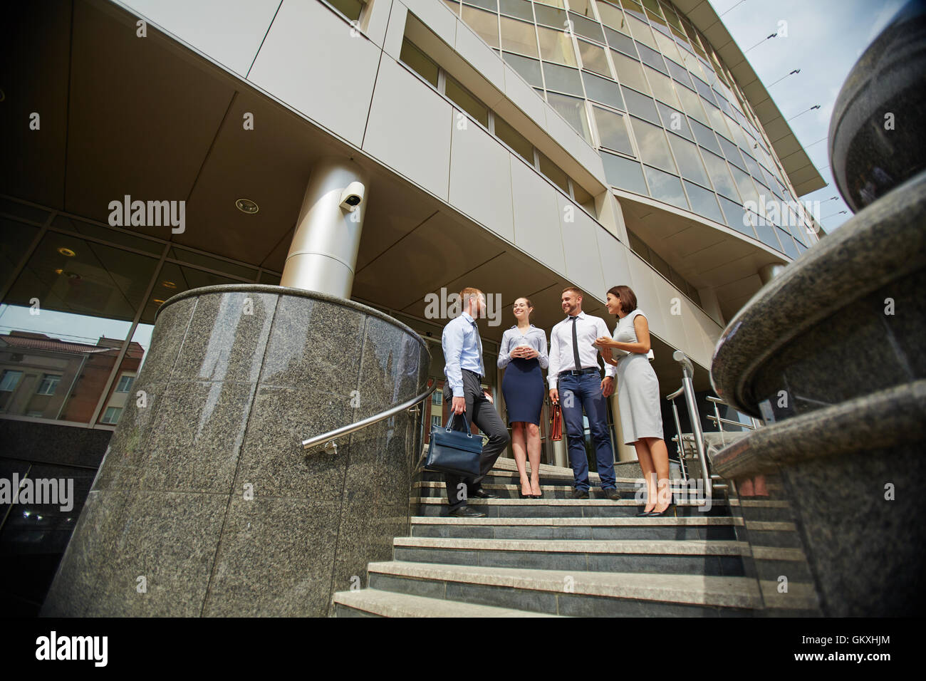 Colleagues standing on stairs in front of office center Stock Photo - Alamy