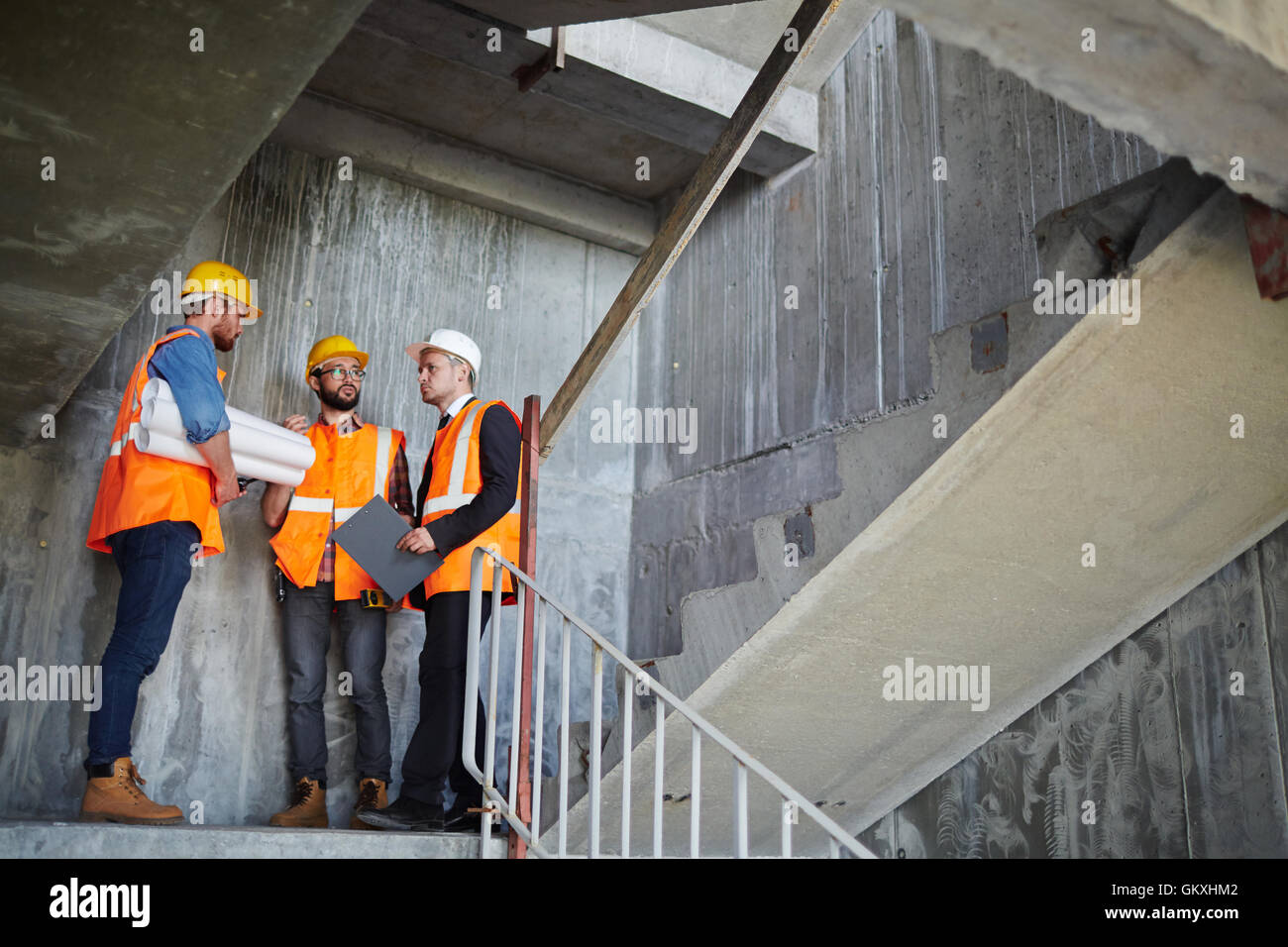 Group of inspectors discussing quality of newly done work Stock Photo ...