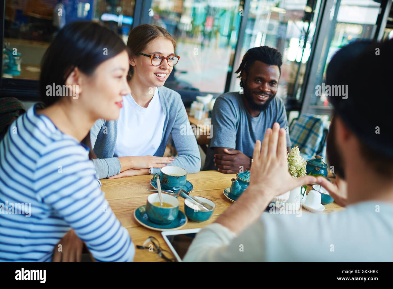 Friends having tea in cafe and talking Stock Photo - Alamy