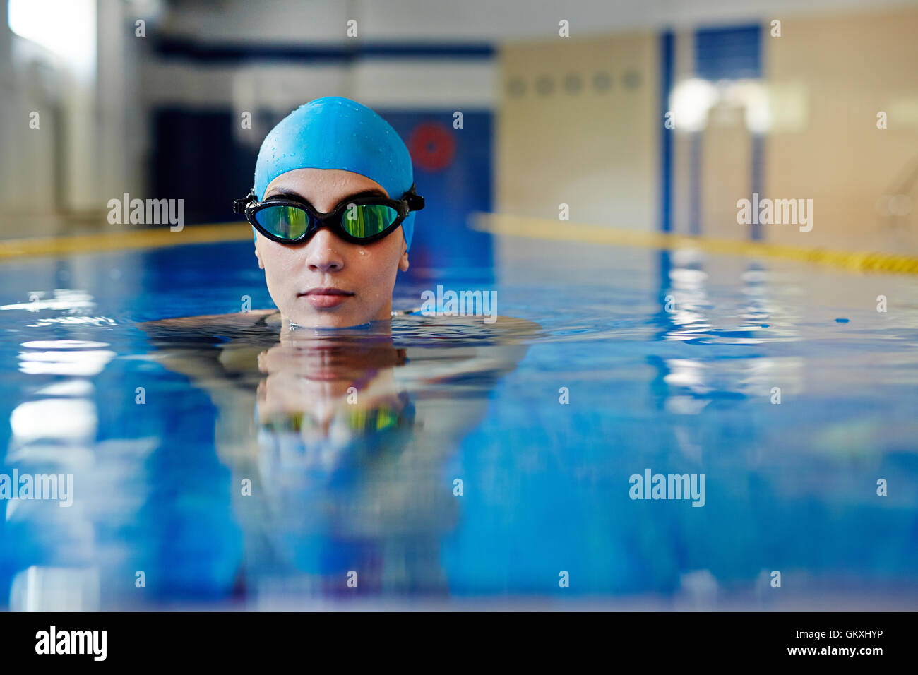 Swimmer in rubber cap and goggles looking out of water Stock Photo - Alamy