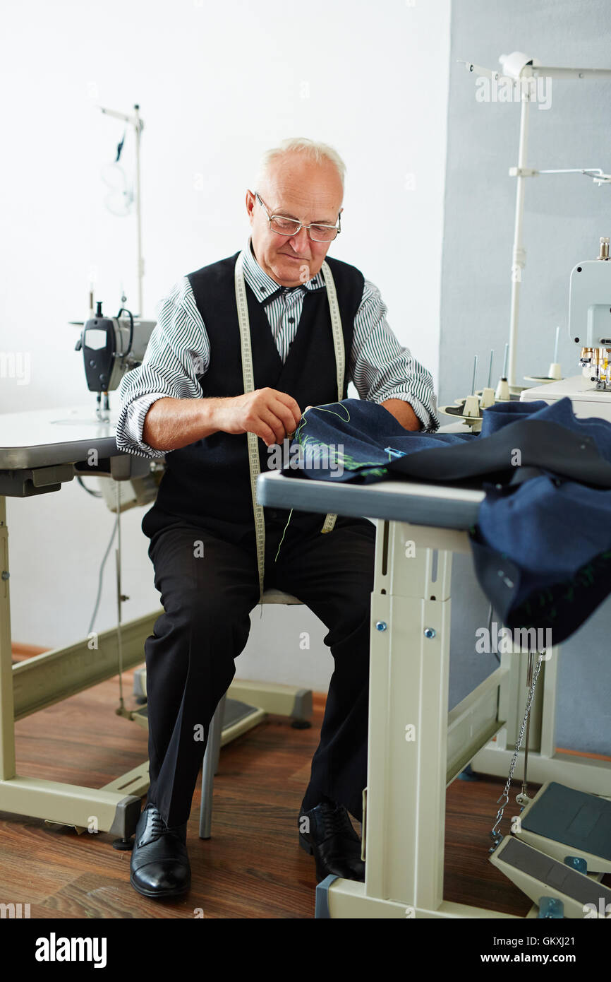 Professional tailor sewing clothes in workshop Stock Photo - Alamy