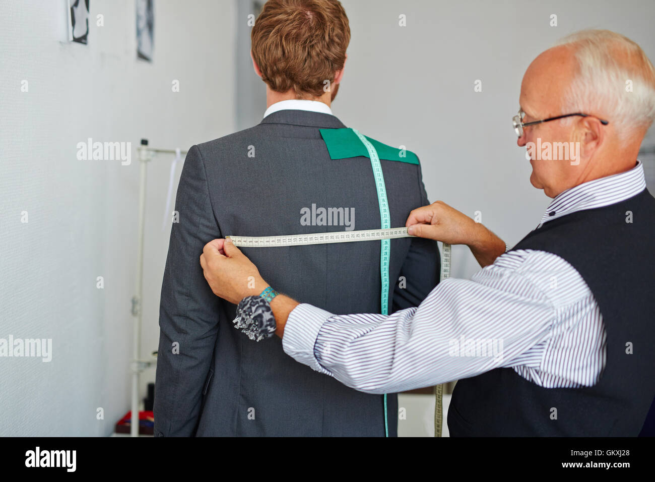 Modern tailor measuring back of male jacket Stock Photo - Alamy