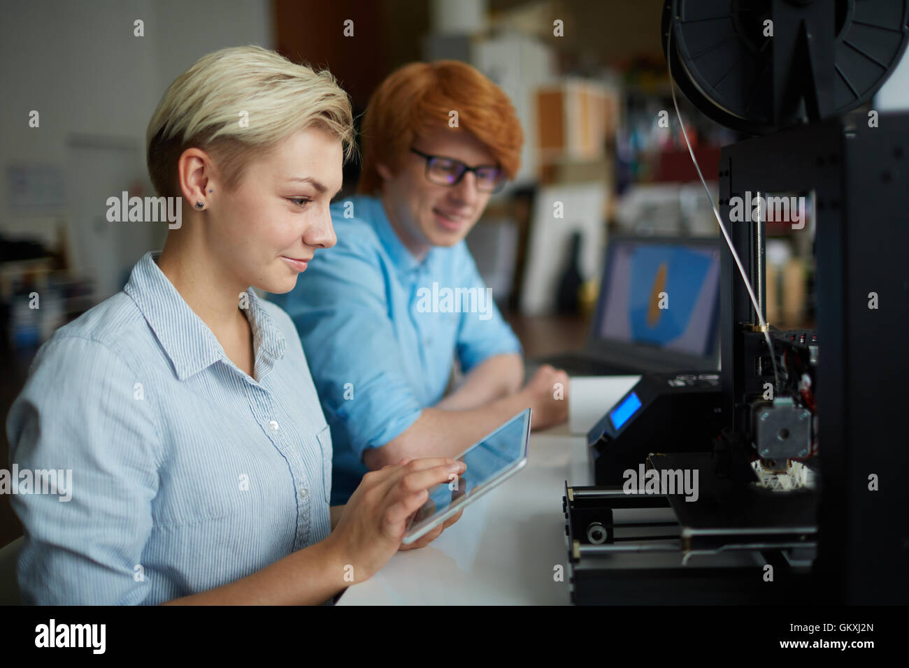 Young designer with touchpad networking in front of 3d printer Stock ...