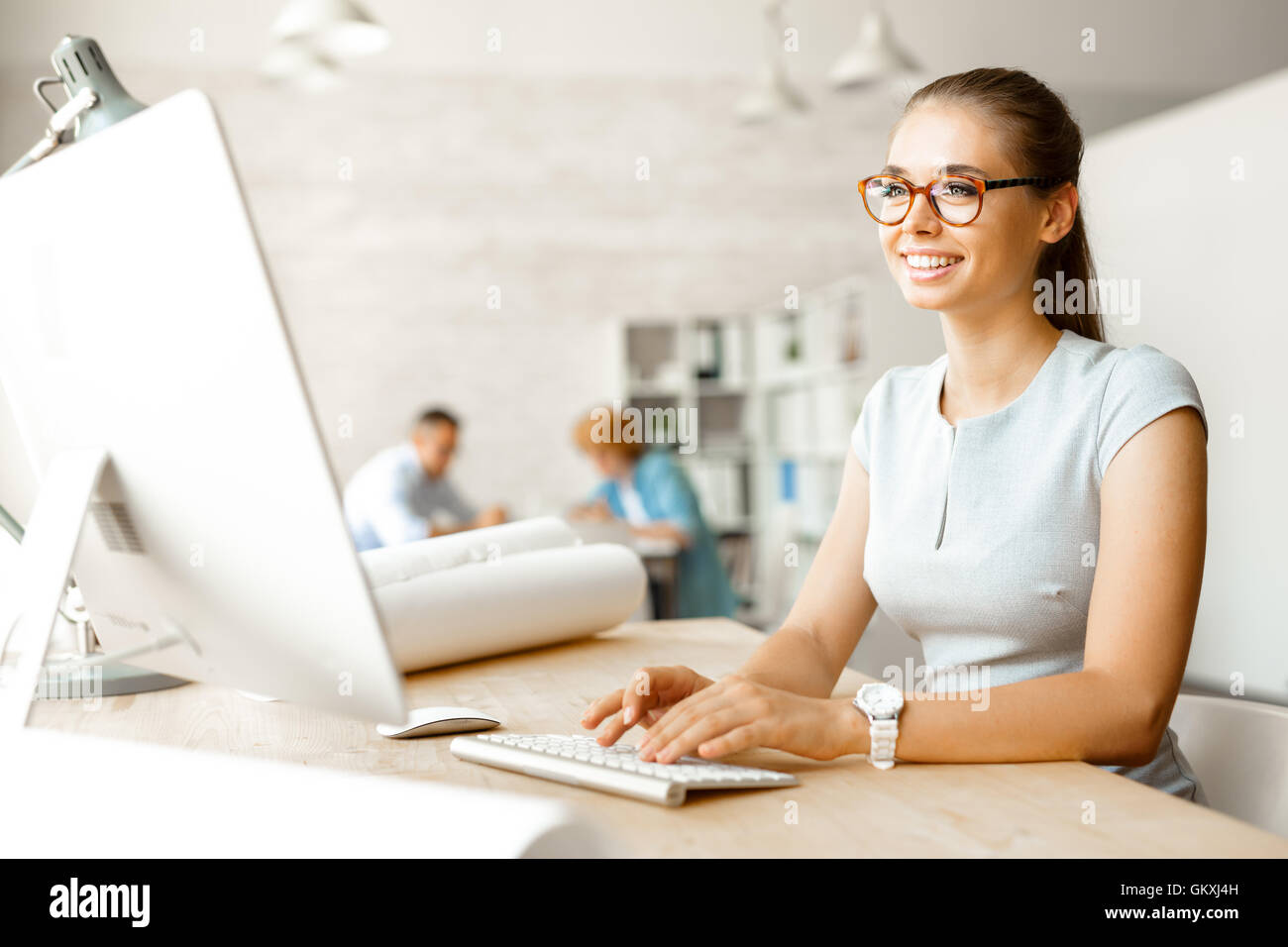 Young designer sitting in front of computer monitor in office Stock ...