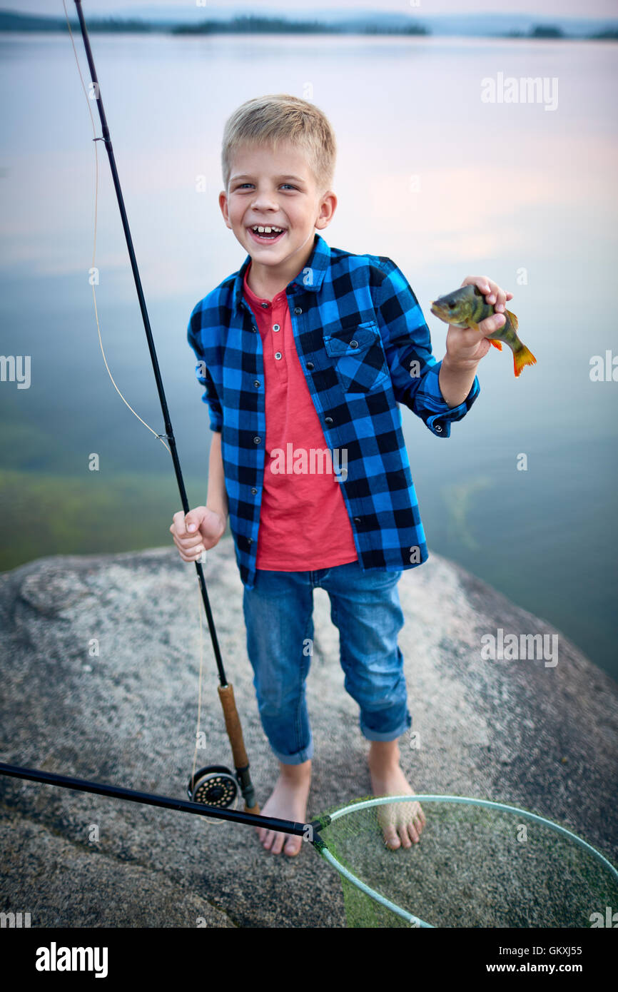 Successful boy with rod showing caught perch Stock Photo - Alamy