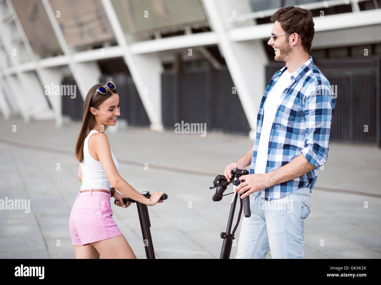 Joyful friends riding kick scooter Stock Photo - Alamy