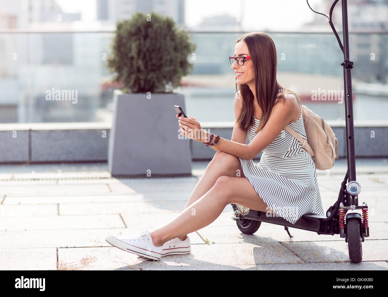 Positive woman using cell phone Stock Photo - Alamy