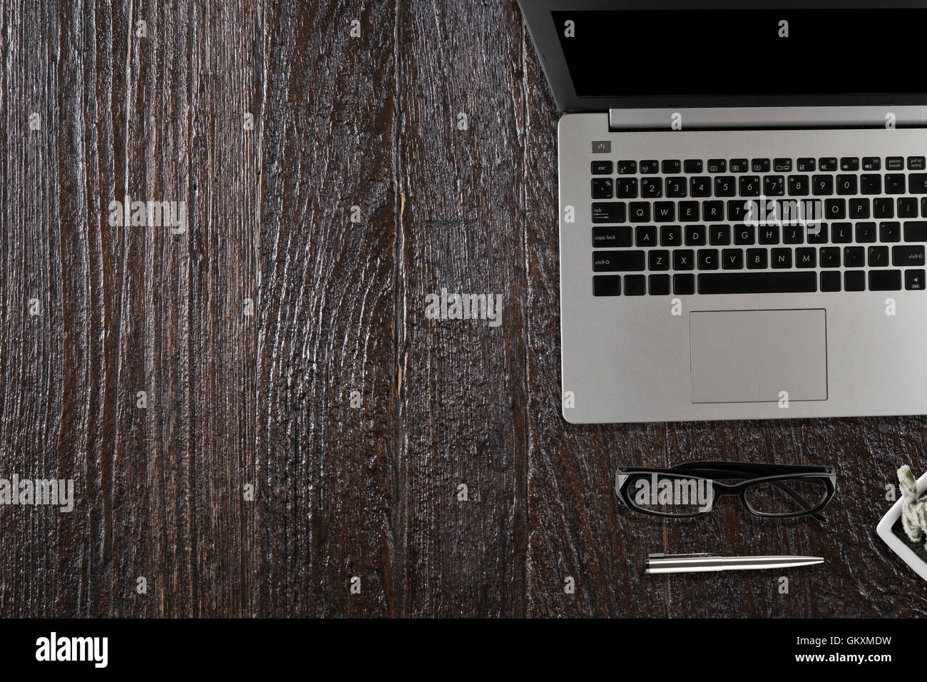 laptop computer, black eyeglasses, cactus pot and pen on wood office ...